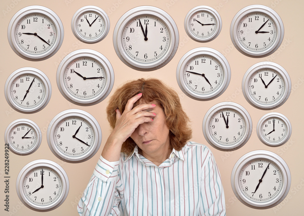 Tired middle aged woman with a lot of clocks around her head. Each ...