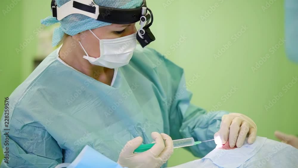 anesthesiologist is injecting anesthetic in skin of nose of patient ...
