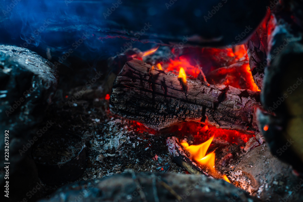 Smoldered logs burned in vivid fire. Atmospheric background with orange ...