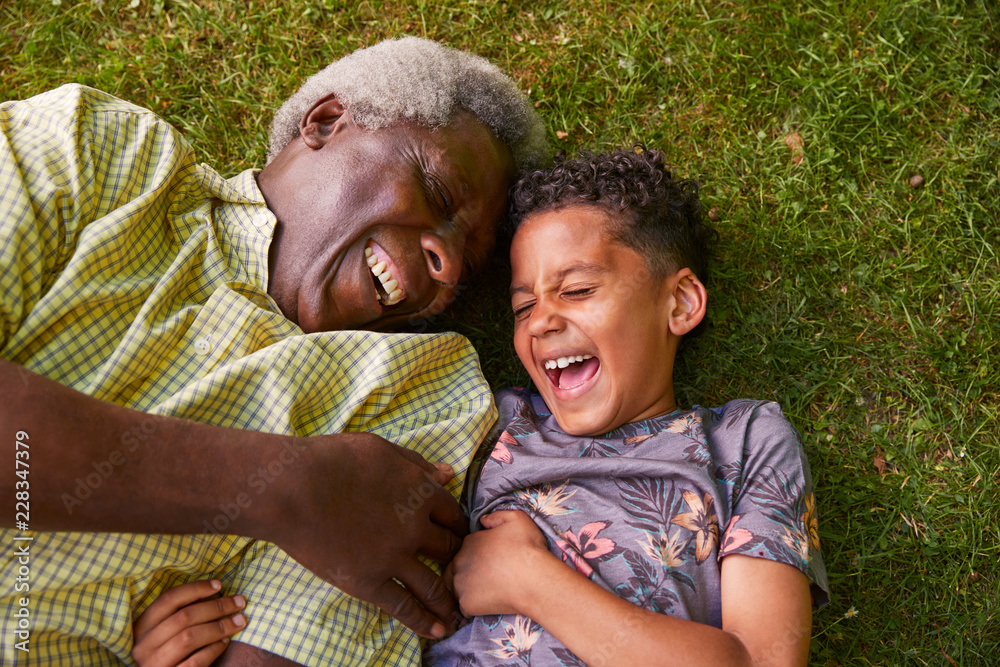 Laughing boy and granddad lying on grass, overhead close up Stock Photo ...