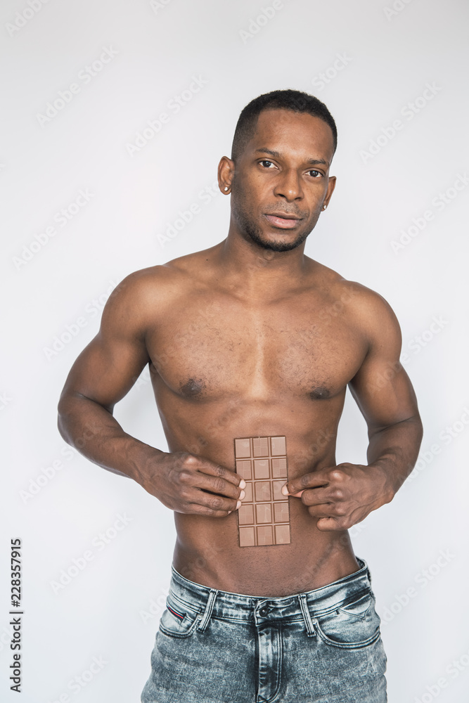 Crop black shirtless man with bar of chocolate Stock Photo | Adobe Stock