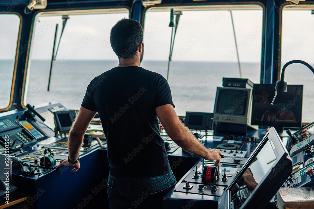 Marine navigational officer is maneuvering ship or vessel during ...