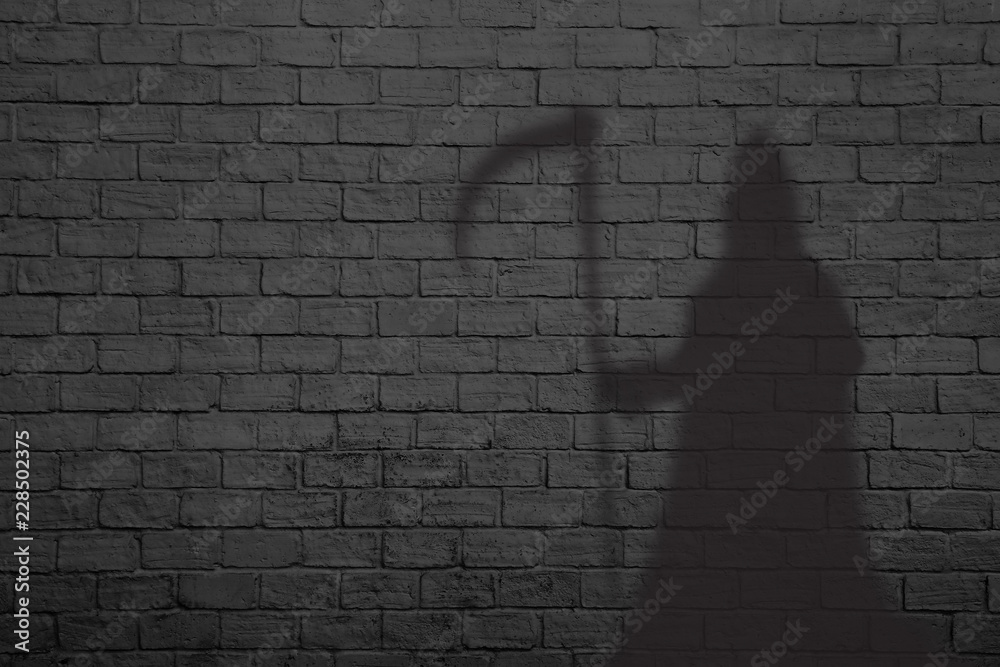 Ghost shadow standing on black brick wall Stock Photo | Adobe Stock