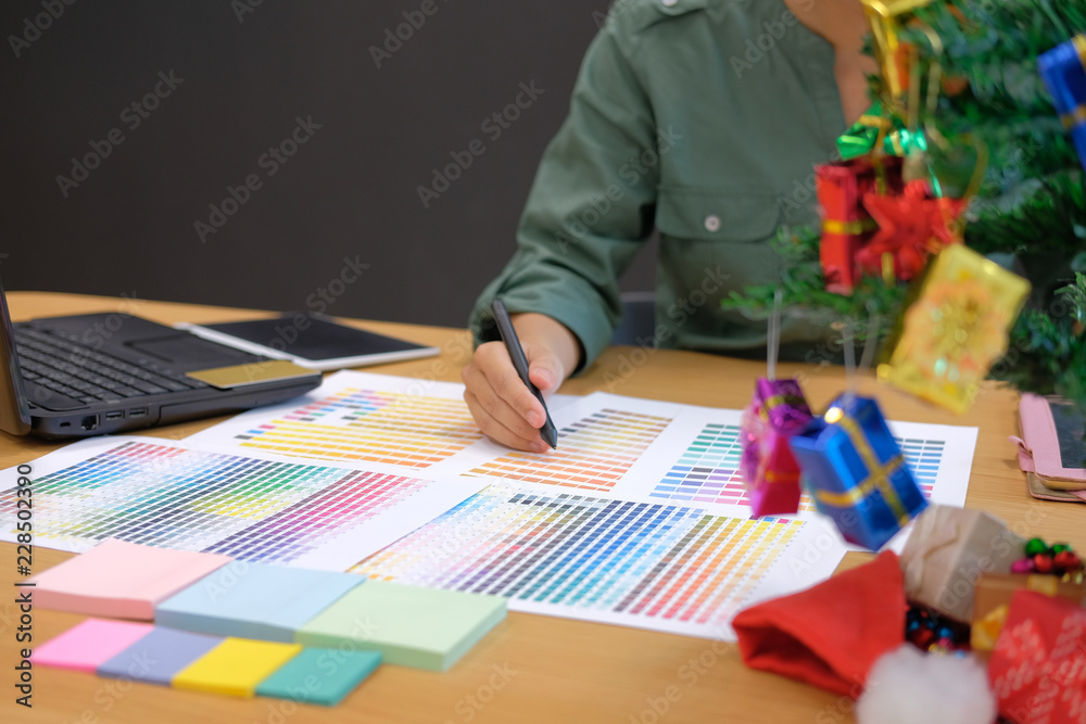 graphic interior designer choosing color from swatch sample catalogue ...