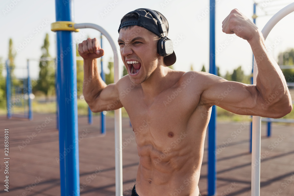 Motivated young male working out on sports ground enjoying the victory ...