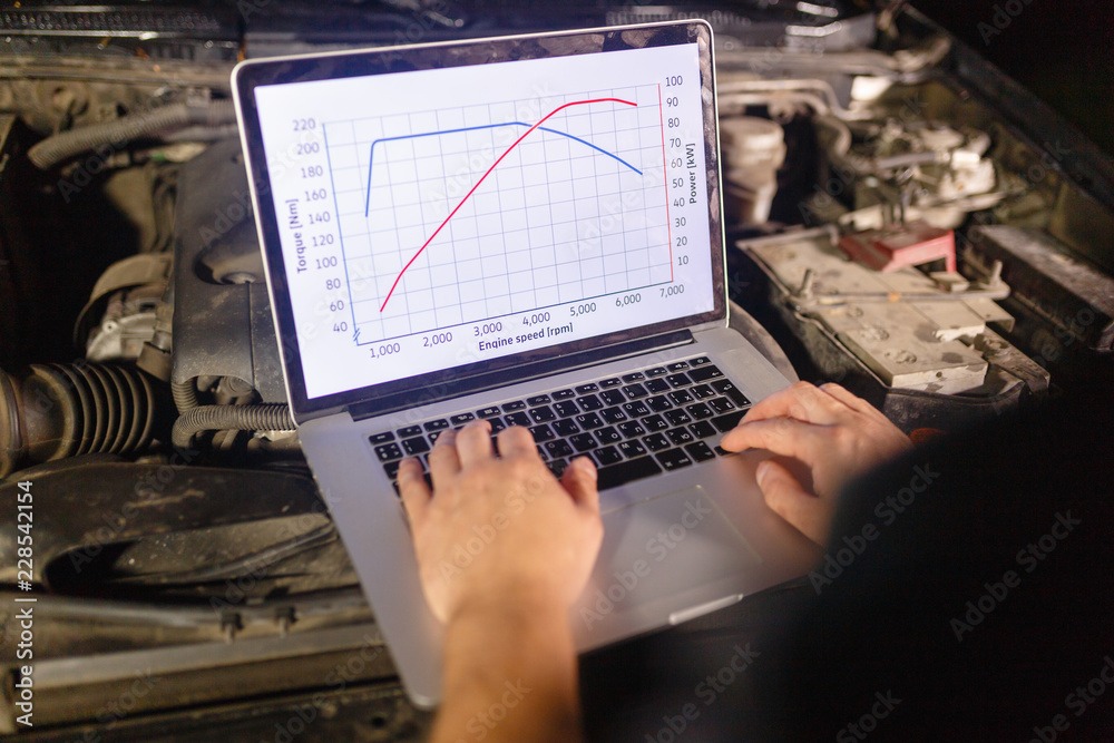 Closeup hands of mechanic with the help of diagnostic machines is ready ...
