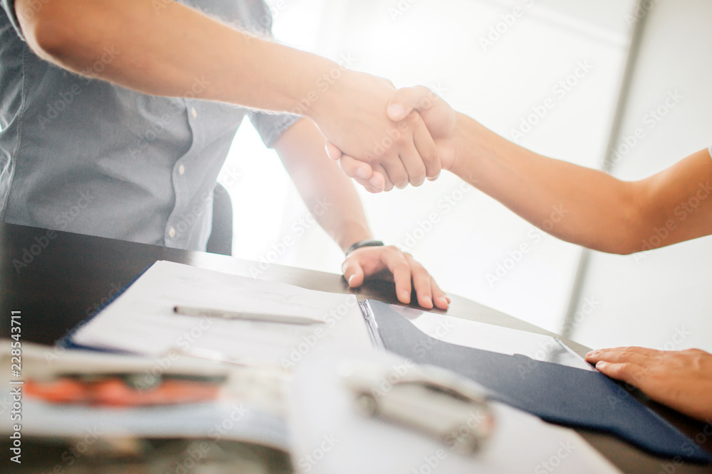 Agreement between two young men. They shake each other's hands. There ...