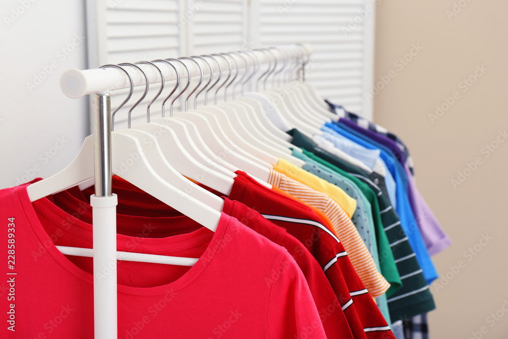 Rack with bright clothes in room. Rainbow colors Stock Photo | Adobe Stock