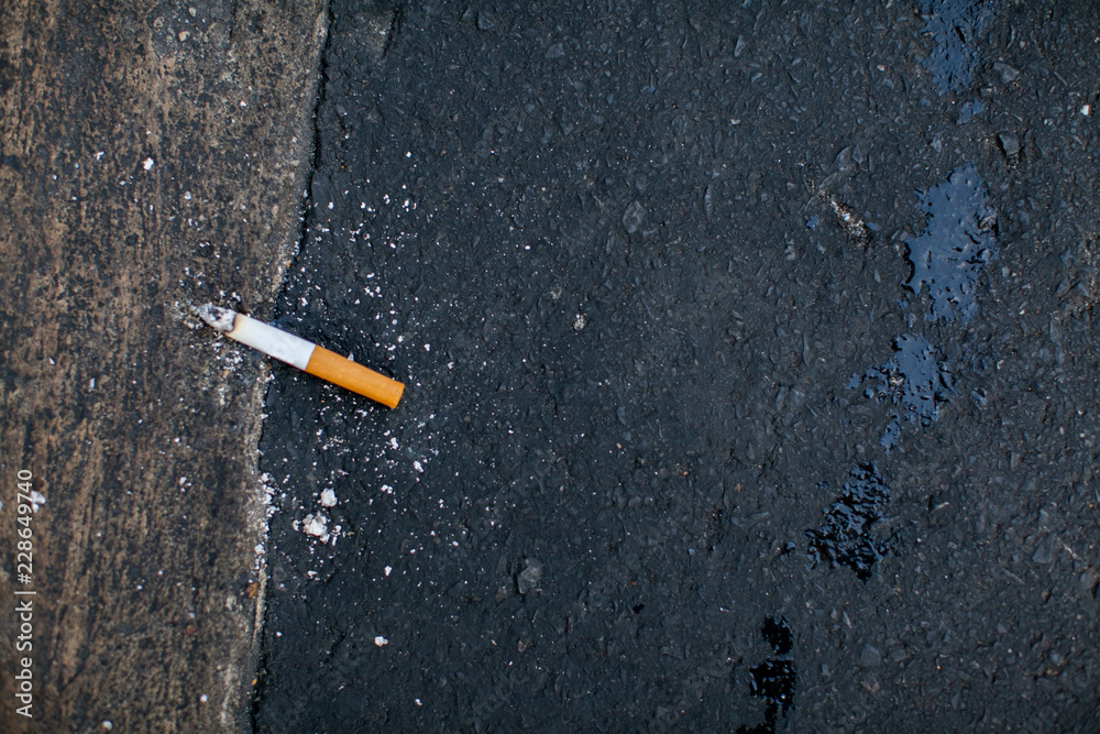 Cigarette butts on the street.Cigarette stub on the floor black ...
