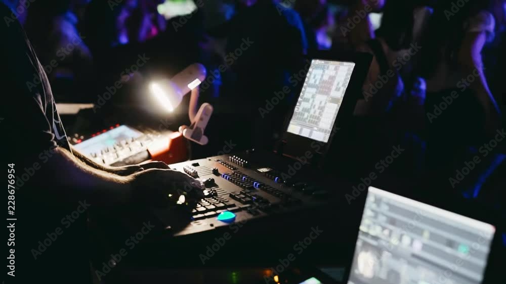 Light engineer working at mixing panel. Light console to adjust the ...