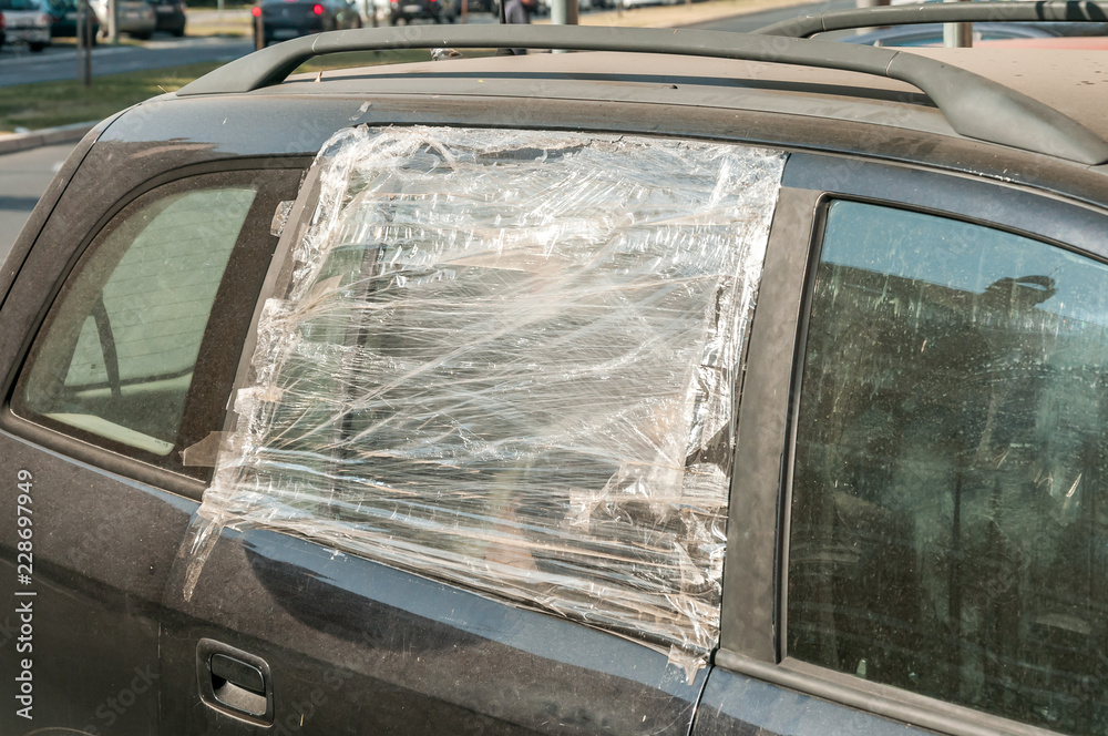 Broken and damaged shattered glass of the car side window protected ...