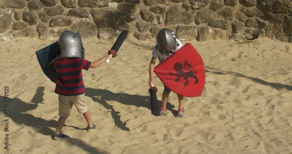 two children in helmets with shields fight with soft swords Stock Video ...