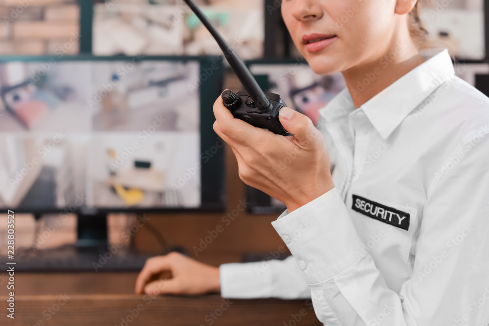 Female security guard with portable transmitter at workplace, closeup ...