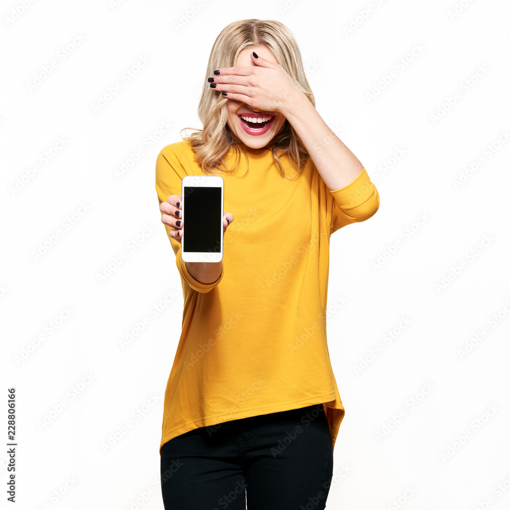 Gorgeous laughing woman showing blank screen mobile phone over white ...