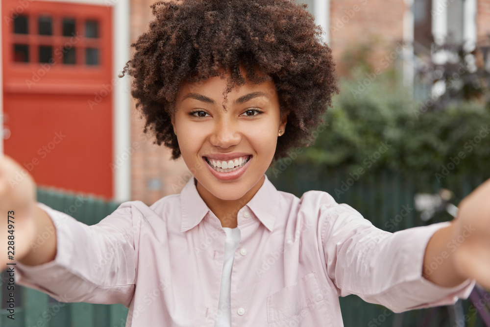 Headshot of black woman with toothy smile, Afro hairstyle, has cheerful ...
