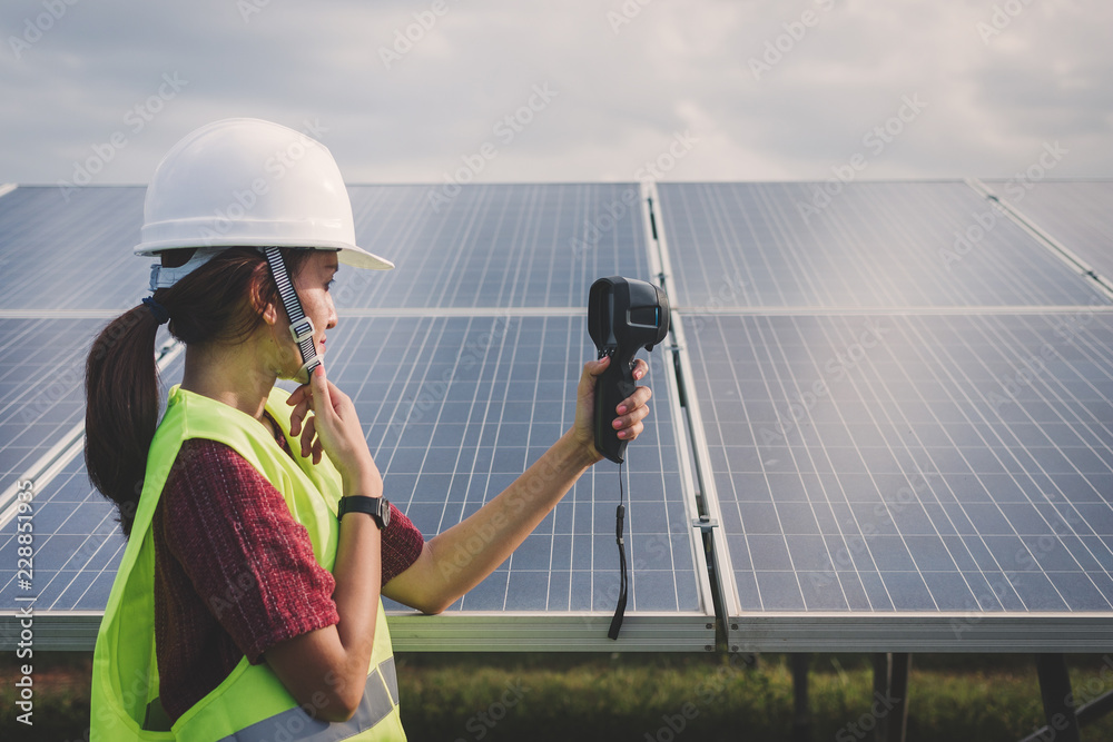 woman engineer checking heat of solar panel and using ir camera to scan ...