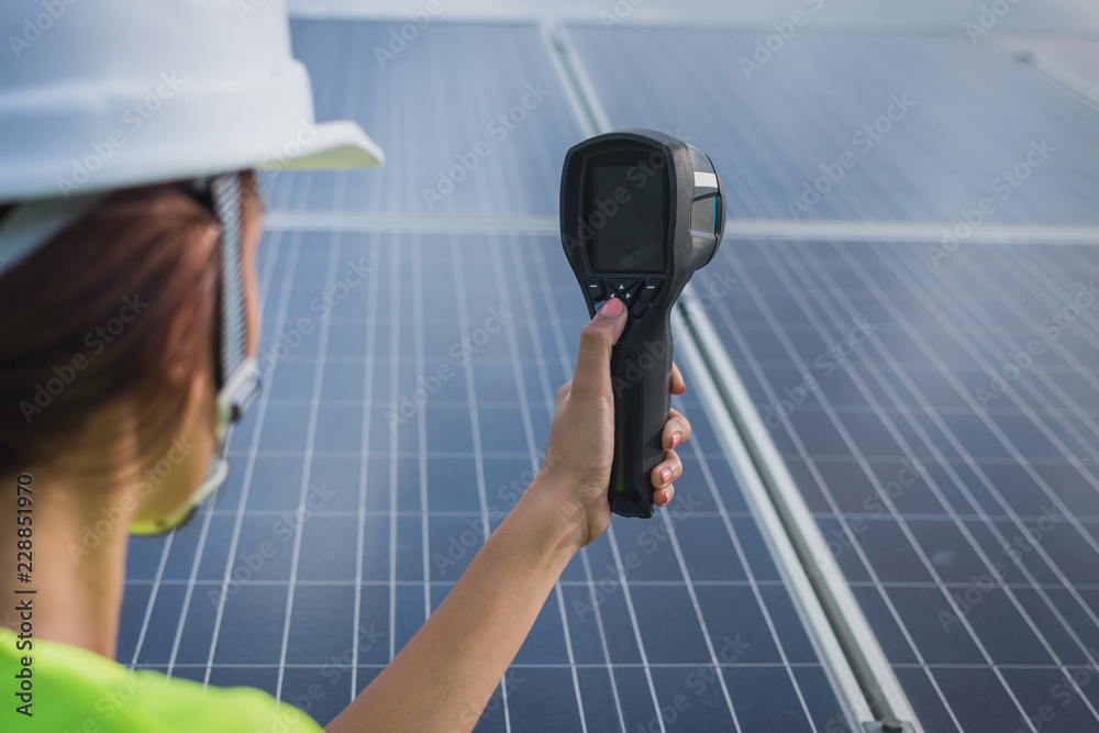 woman engineer checking heat of solar panel and using ir camera to scan ...