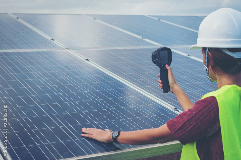 woman engineer checking heat of solar panel and using ir camera to scan ...