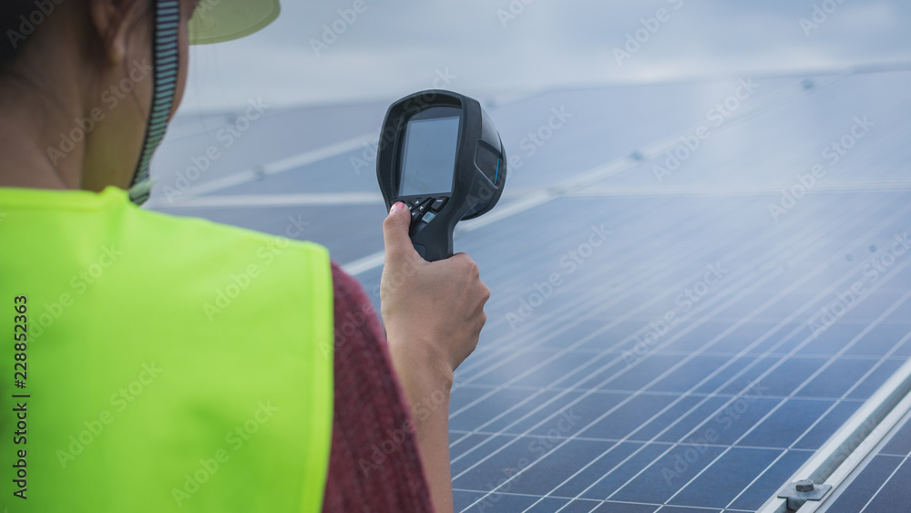woman engineer checking heat of solar panel and using ir camera to scan ...