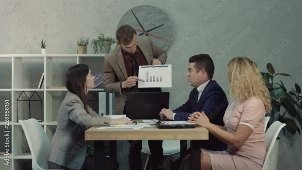 Confident boss in formal wear communicating with employees about ...