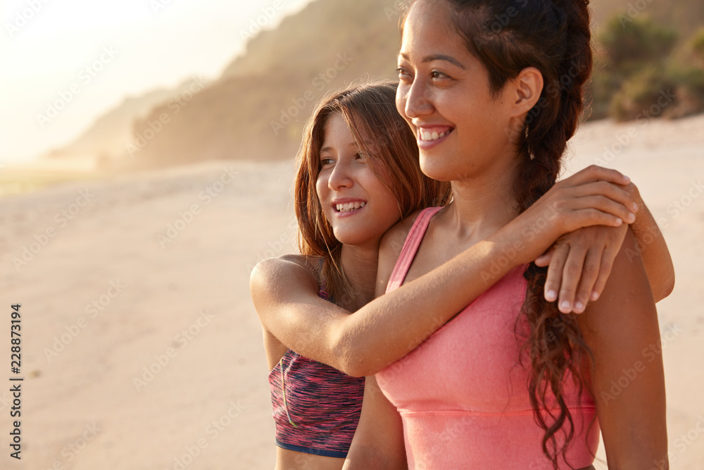 Homosexual women embrace with love, look positively at ocean, have ...