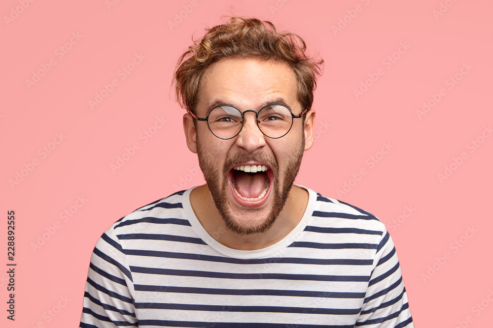 Crazy man yells loudly, has overjoyed facial expression, shouts for his ...