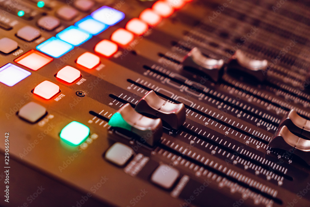 mixing console for recording with faders and bright buttons is in the ...