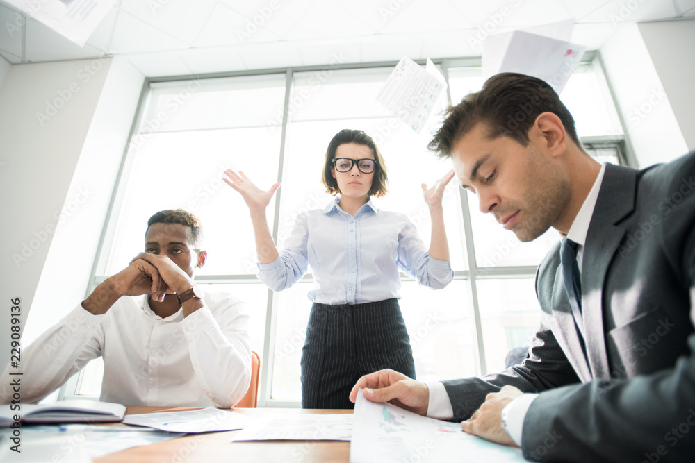 Sad displeased young lady boss in glasses disappointed in her employees ...