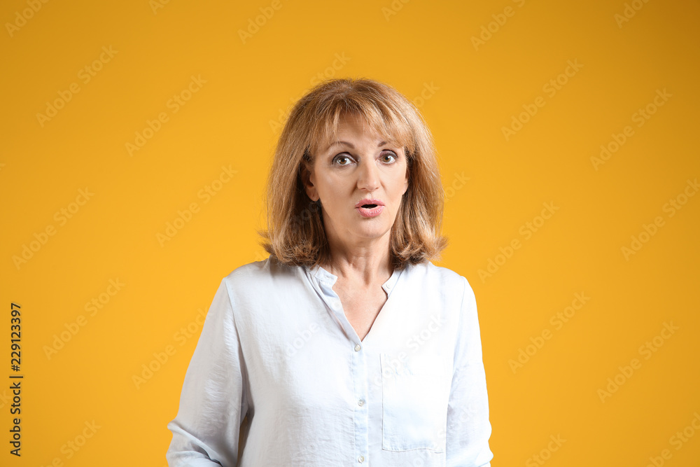 Portrait of confused mature woman on color background Stock Photo ...