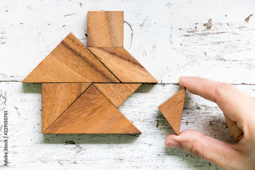 Tangram puzzle wait to fulfill home shape on old white wood background ...