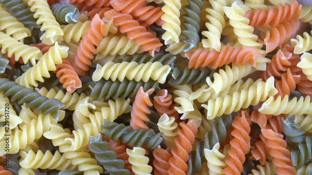 Multicolored pasta background, rotating, top view. Rotation of colored ...