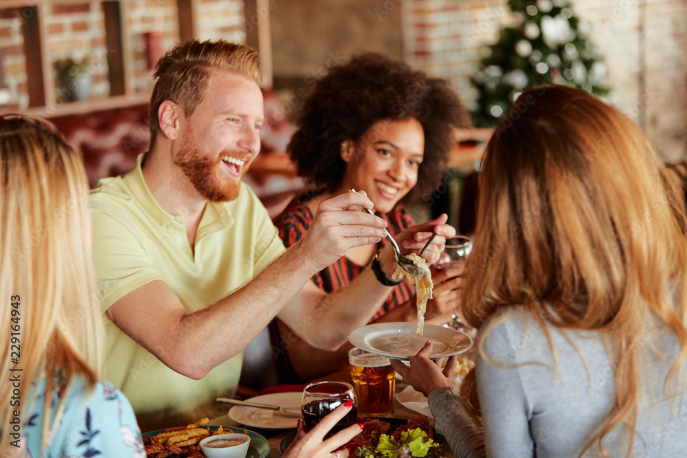 Friends having dinner at home. Table full of food. Friends at diner ...
