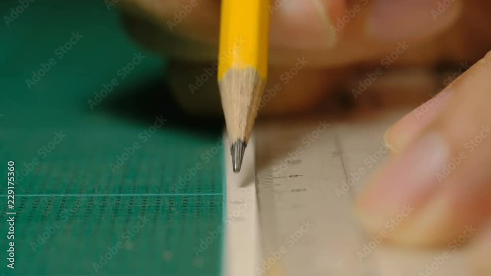 Close-up of male architect hands drawing mark on white paperboard with ...