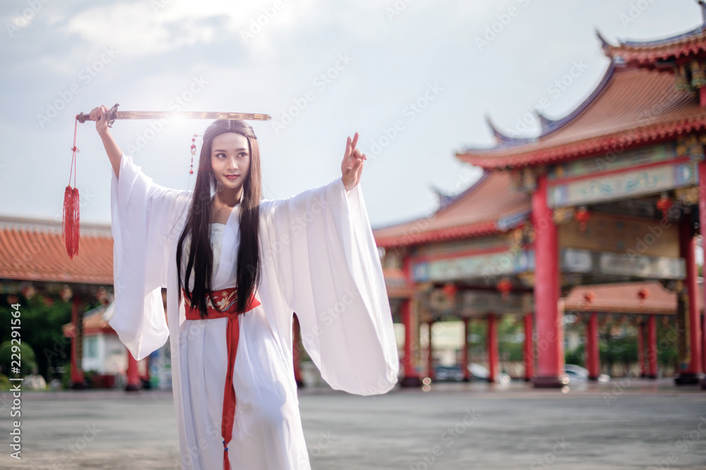 Beautiful Chinese woman with a traditional suit with a sharp sword in ...