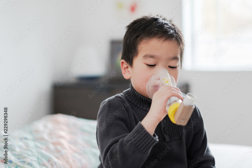 Boy using asthma inhaler at home Stock Photo | Adobe Stock