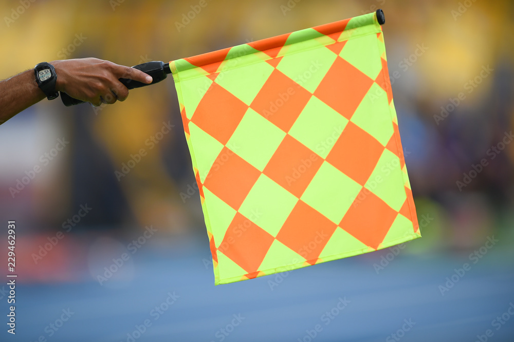 Assistant referee hold flag , offside signal. Stock Photo | Adobe Stock