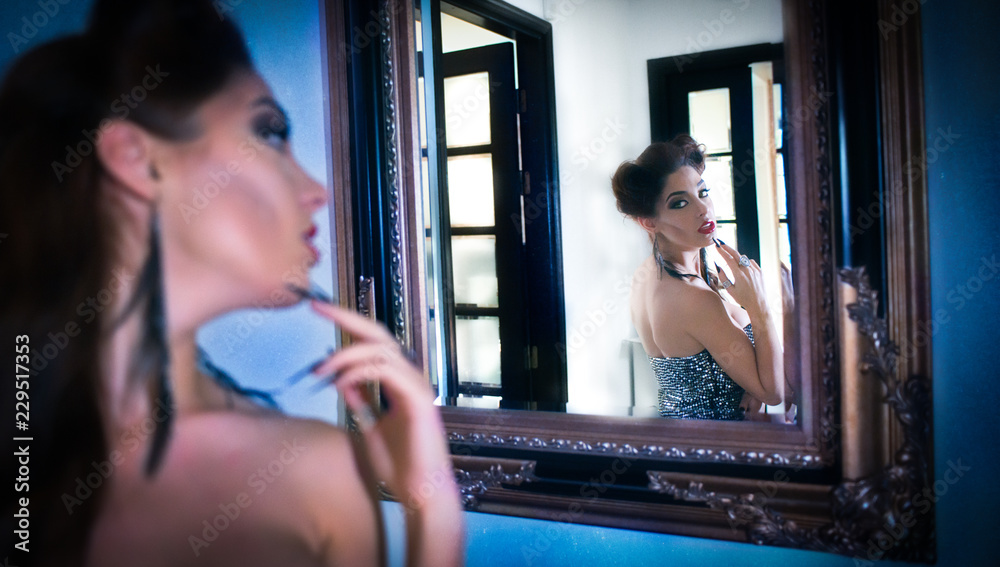 Sexy woman model looking like a vampire, seeing her reflection in the ...