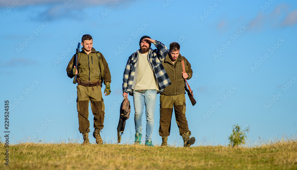 Hunting as hobby and leisure. Hunters with guns walk sunny fall day ...