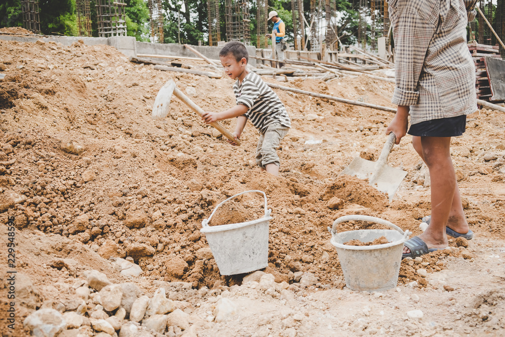 Little boys labor working dig the ground in commercial building ...