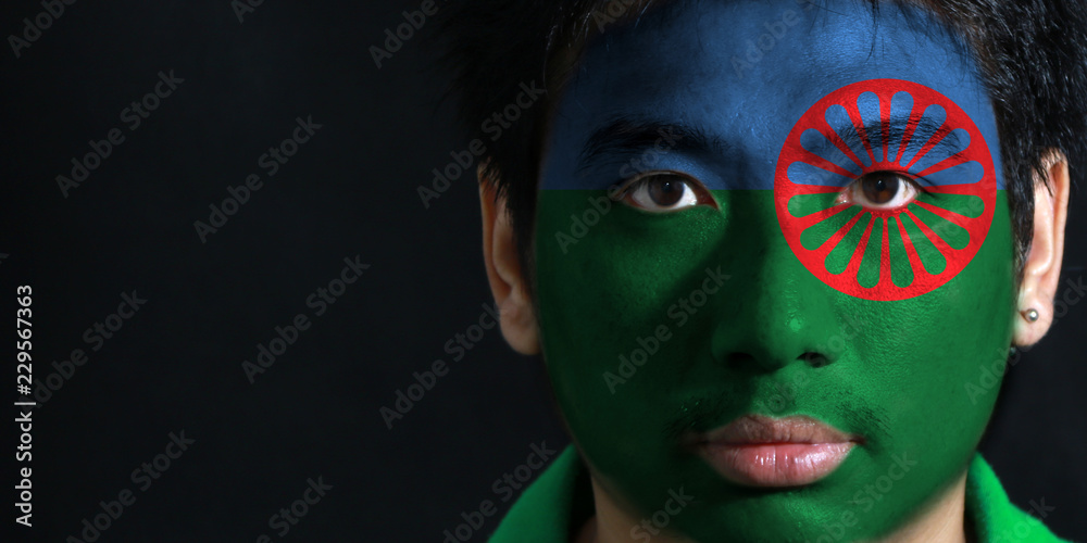 Portrait of a man with the flag of the Romani people painted on his ...