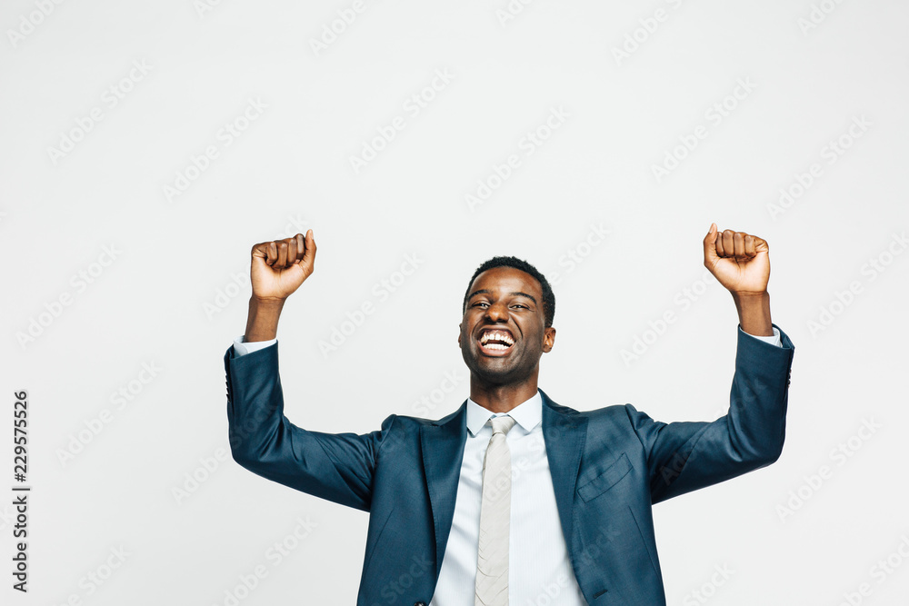 Celebrating success, Portrait of a happy young man in business suit ...