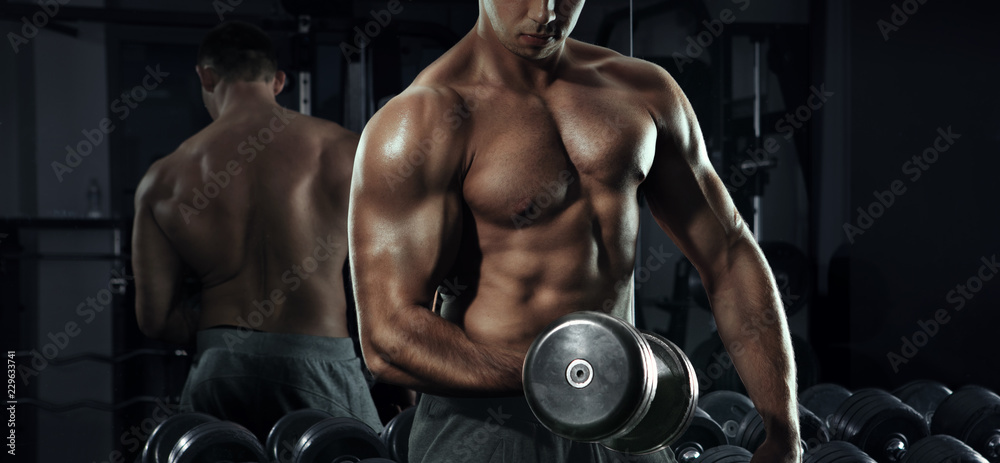 Sport and fitness. Muscular bodybuilder in the gym training with ...