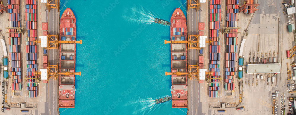 Aerial view Tug boats drag container ship to sea port and working crane ...