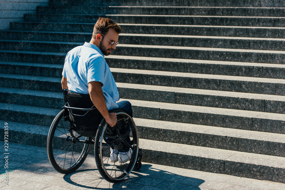 handsome disabled man using wheelchair on street and stopping near ...