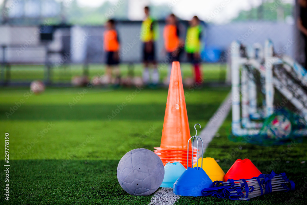 Football and soccer training equipment on green artificial turf with ...