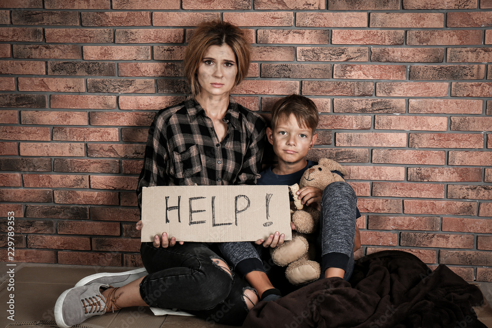 Poor woman with her son asking for help near brick wall Stock Photo ...