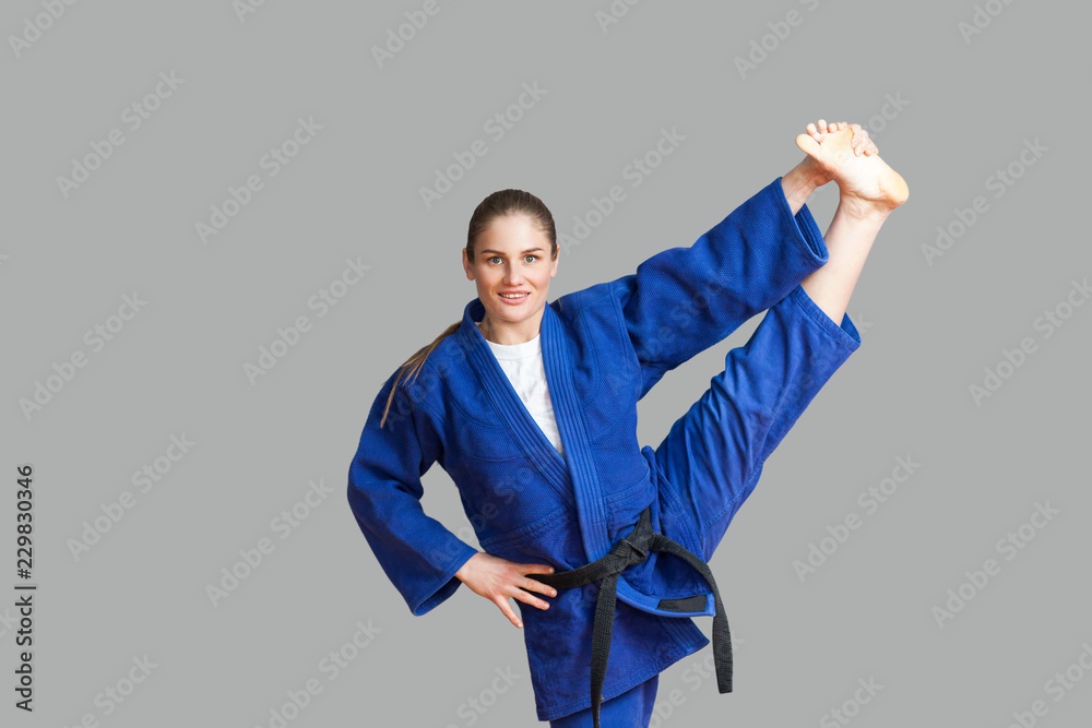 Beautiful happy athletic karate woman in blue kimono with black belt ...