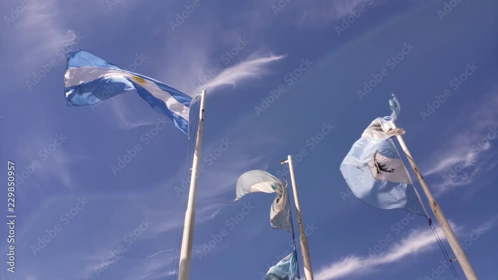 3 flags slowly waving in a blue sky. 3 banderas flameando lentamente en ...