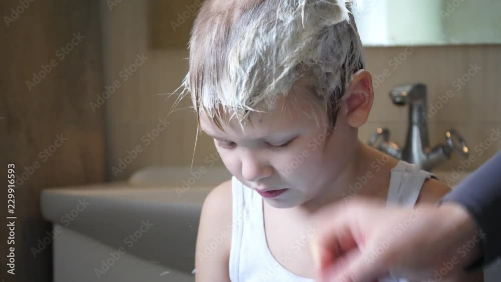 Video Stock Young mother shaves head of blond boy with razor for ...