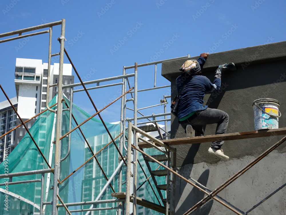 Brick wall plastered by construction workers using the cement plaster ...